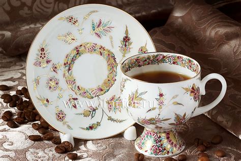 a coffee cup and saucer sitting on top of a table covered in coffee beans