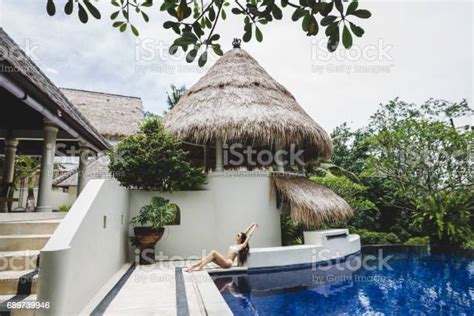 열 대 휴양지에서 깊고 푸른 물으로 수영장 근처 휴가 즐기는 여자 스파 유기농 스킨 케어 건강 한 라이프 스타일 자 쿠지