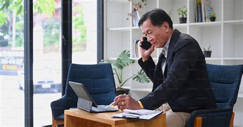 성숙한 사업가는 휴대 전화로 이야기하고 현대 사무실에서 일하고 있습니다 사진 Unsplash의 작업 이미지