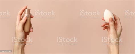 중성 베이지 색 배경 배너 복사 공간 전단지 Beuty 산업 메이크업 아티스트 블로거 개념에 화장품 파운데이션 또는 컨실러 및 스폰지 병을 보여주는 여성의 손의 클로즈업