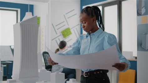 Woman Architect Analyzing Building Model And Blueprints Plans For Project Development 4559554