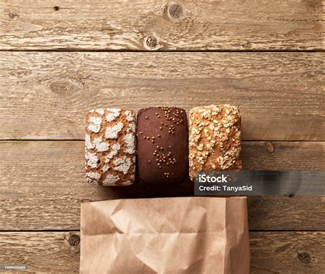 종이 패키지와 나무 테이블에 빵의 세 덩어리 디자인을 위한 빈 공간을 가진 빵집 개념 글루텐 프리 호 밀 빵 밀기 울과 코리 앤 더 갈색에 대한 스톡 사진 및 기타 이미지