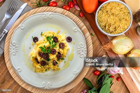 감자 짚 혼합 계란 다크 올리브와 잘게 썬 대구의 전형적인 포르투갈 요리 마늘 양파 파슬리 등 나무 테이블에 맨 위 보기입니다 텍스트 공간입니다 마른 대구에 대한 스톡 사진