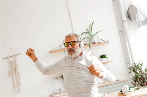 노인 남자 댄스 및 모바일 앱에서 재생 목록 음악을 만들기 위한 스마트폰 앱 사용 휴대 전화 기술로 즐겁게 춤을 추는 노인 남성 기술과 즐거운 노인 라이프 스타일 개념 70