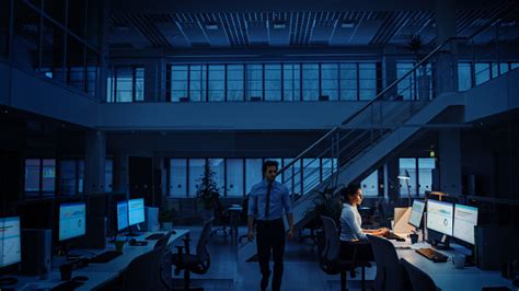 사무실에서 늦은 밤에 작업 데스크톱 컴퓨터를 사용 하 여 사업가 분석 문서 사용 문제 해결 프로젝트를 마무리 동료가 작별 인사를 하고 나뭇잎을 말합니다 밤 하루 시간대에