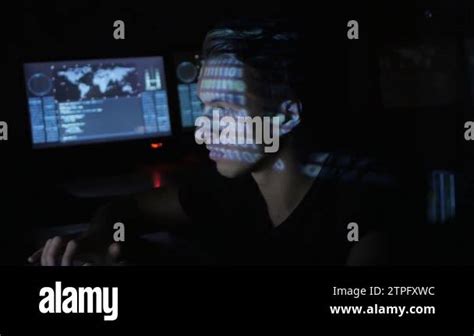 Hacker Programmer In Glasses Is Working On Computer While Blue Code Characters Reflect On His