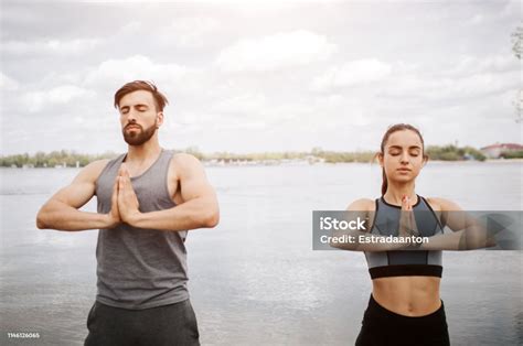 명상 하는 젊은 남자와 여자의 평온 하 고 평화로운 그림 그들은 손을 함께 지키고 눈을 감고 서 있었다 그들은 강 해 안에 서