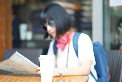 카페에서 백그라운드에서 젊은 여행자 여자와 테이블에 커피 컵 1 개 커피가 게에서 뒤쪽에 여자와 앞에 커피 한잔 거리에 대한 스톡 사진 및 기타 이미지 Istock