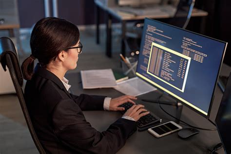 Female Software Developer Writing Code While Using Computer At