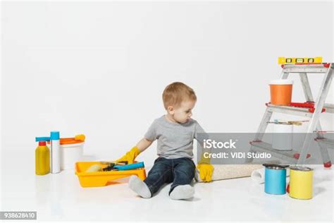 재건축 아파트 룸 흰색 배경에 고립에 대 한 장비와 노란색 장갑에 작은 귀여운 소년 벽지 액세서리를 붙이기 그림 도구 집 수리 부모 어린 시절 개념 개선에 대한 스톡 사진