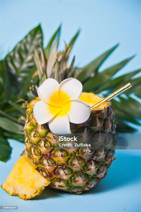 플루메리아 프랑지파니 꽃과 야자수 잎장식이 있는 파인애플에서 이국적인 열대 칵테일 음료를 마시세요 배경에 바다 해안입니다 0명에