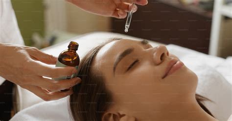 얼굴 피부 관리 미용실에서 혈청 오일 치료를 받는 아름다운 웃는 여자의 근접 촬영 미용센터에서 소녀의 얼굴에 화장품 세럼을 바르는 미용사 고해상도 이미지 사진