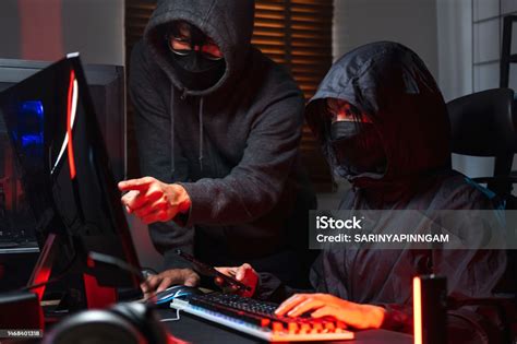 Dangerous Hooded Hacker Typing Bad Data Into Computer Online System And