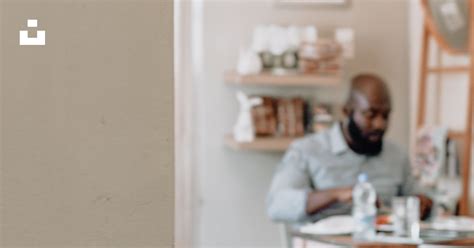 흰색과 갈색 테이블 앞 의자에 앉아있는 남자의 선택적 초점 사진 사진 Unsplash의 무료 보보 텔로 이미지