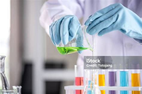 실험실 배경 과학 또는 의학 연구 및 개발 개념에 실험실 유리를 가진 플라스 크에 있는 샘플링 기름 또는 화학 액체를 들고 있는 과학자 Stem 주제에 대한 스톡 사진 및