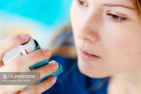 Asthma Woman Using An Aerosol Inhaler That Contains Bronchodilator For The Treatment Of Asthma