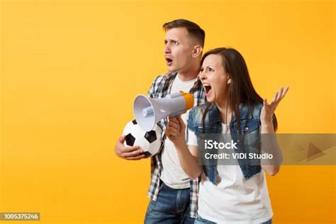 화가 생상 미친 커플 여자 남자 축구 팬 들 비명 손실의 화가 축구 공 노란 배경에 고립 된 확성기 좋아하는 팀의 목표 스포츠