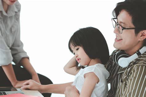 방에 있는 테이블에서 노트북을 사용하는 어린 아이 집에서 부모와 함께 공부하는 소녀 아버지와 어머니 교육 딸 함께 장치와 학습 기술을 재미 행복한 가족 가정 생활에 대한