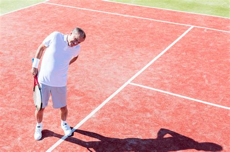 화창한 날에 경기 중 레드 코트에서 요 통으로 서 있는 수석 남자의 전체 길이 허리통증에 대한 스톡 사진 및 기타 이미지 허리통증 노인 놀기 Istock