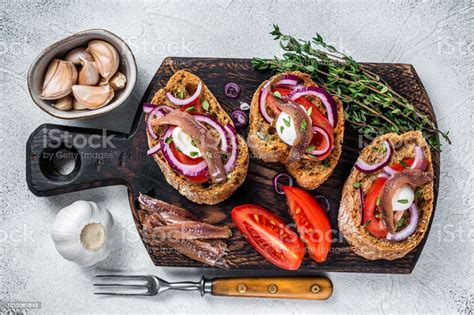 올리브 오일 허브 토마토 매운 멸치 필렛을 곁들인 토스트 흰색 배경입니다 위쪽 보기 0명에 대한 스톡 사진 및 기타 이미지 Istock