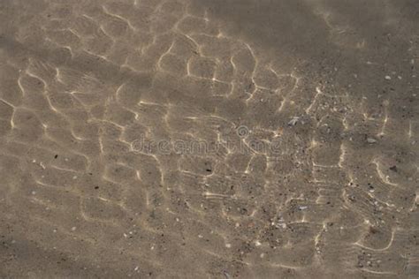 A Mesmerizing View Of Sunlight Reflecting On Shallow Water Creating Rippling Patterns On The