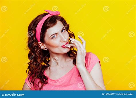 Girl In Pink Dress Pinup Style Eats Cream Licks Fingers Stock Image