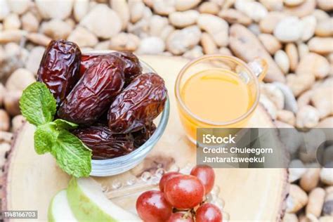 라마단 개념과 나무 쟁반에 포도 구아바 슬라이스 및 오렌지 주스와 같은 혼합 과일의 세트와 함께 맑은 그릇에 많은 날짜 손바닥을 보여주는 영감 0명에 대한 스톡 사진 및