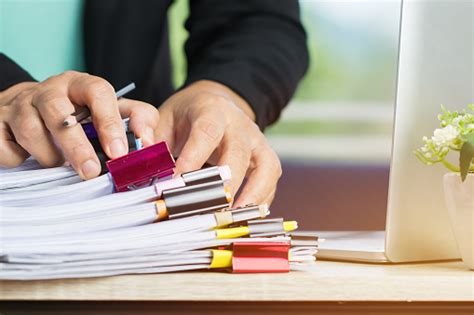 실업가 손을 들고 연필 종이 파일 정보 비즈니스 보고서 논문 검색의 더미에서 작업을 위한 컴퓨터 책상에 성공 투자 개발에 대 한