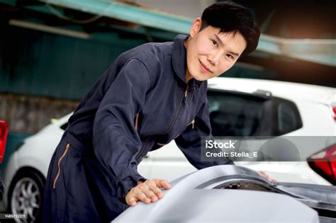 자동차 부품 엔진 차량과 함께 일하는 제복을 입은 아시아의 잘생긴 정비사 남자 차고 자동차 수리 서비스 상점에서 고객 자동차