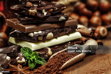 나무 테이블에 민트 잎 초콜릿 조각의 스택 흰색 어두운 밀크 초콜릿에 고급 초콜릿의 구색 달콤한 음식 사진 개념 검은색에 대한