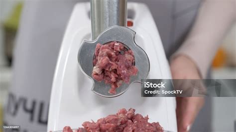 집에서 신선한 쇠고기에서 전기 고기 분쇄기에 다진 고기를 만들기 다진 고기 더미 신선한 다진 고기와 전기 광부 기계 전기 고기 분쇄기로 다진 쇠고기의 준비 가루로 빻은에