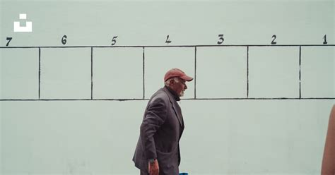 회색 재킷과 파란색 데님 청바지를 입은 남자가 낮에 흰 벽 옆에 서 있다 사진 Unsplash의 무료 의복 이미지