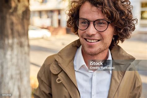 근접 촬영 안경 웃 고 야외 포즈 젊은 사업가의 초상화 남자 대학생이 거리 곱슬 머리 길을 걷고 캐주얼 착용 안경에 똑똑한 사람 거리에 대한 스톡 사진 및 기타 이미지