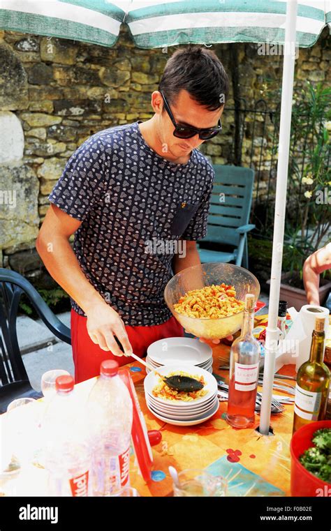 Young Man Serving Pasta Lunch At Holiday Gite At Frayssinet Le Gelat In