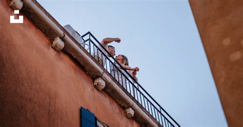 위티 크루넥 셔츠를 입은 남자와 흰 블라우스를 입은 여자가 지붕 위에서 이야기하고 있다 사진 Unsplash의 무료 베네치아 이미지