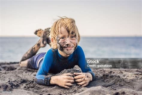 블랙 프라이데이 컨셉 더러운 검은 얼굴 앉아 바다에서 수영하기 전에 검은 모래 바다 해변에서 재생 웃는 소년 가족과 함께 하는 여름 방학에 가족 활동 라이프 스타일 수중