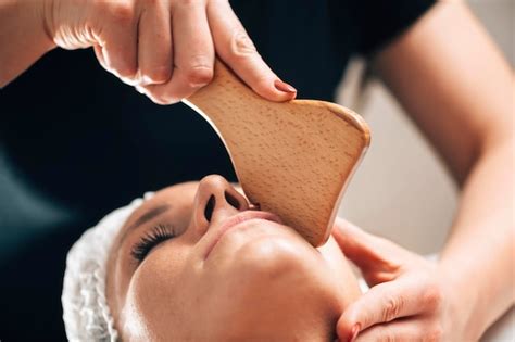 Premium Photo Face Massage With Wooden Gua Sha Plate Shape Massager
