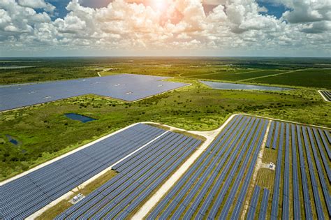 청정 전기 에너지를 생산하기 위한 많은 태양광 전광 패널이 있는 대규모 지속 가능한 전력 발전소의 공중 보기 제로 배출 개념을 가진 재생 가능 전기 공장 산업 건물에 대한