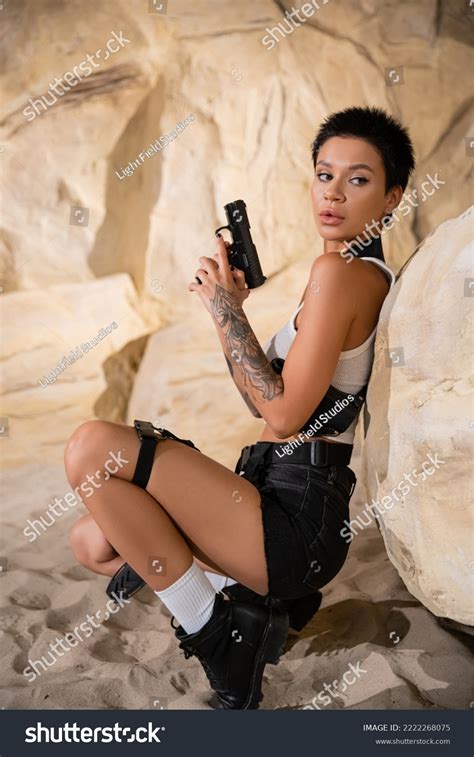 Sexy Archaeologist Short Hair Holding Gun Stock Photo