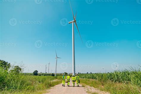 Four Young Male Wind Farm Engineers Work Inspecting Field Systemswind
