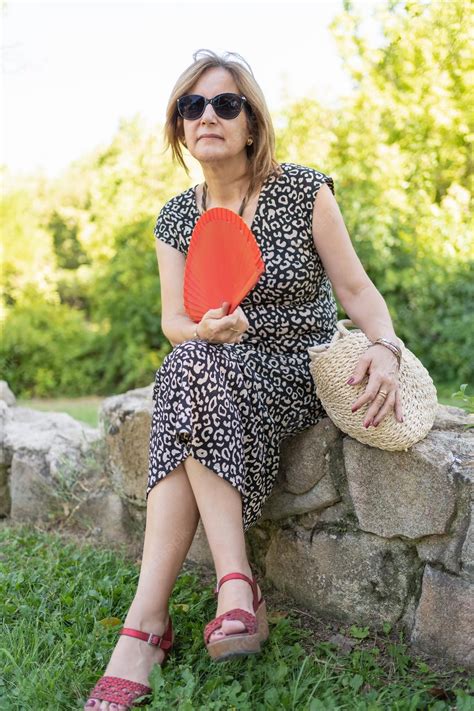Premium Photo Mature Woman With A Fan And Sitting In An Outdoor Park