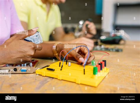 Close Up Female Student Hands Creating Electronic Circuits And Robotics