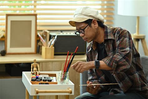 편안한 아트 스튜디오에서 캔버스에 그림을 그리는 젊은 재능있는 남성 예술가의 사진 그리기에 대한 스톡 사진 및 기타 이미지