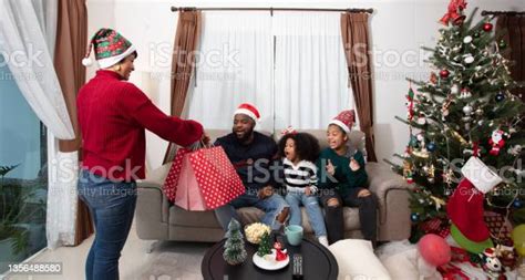 엄마로부터 크리스마스와 새해를 위한 특별 선물 엄마는 남편과 아이들에게 선물 가방을 준다 가리키기에 대한 스톡 사진 및 기타