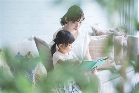 엄마와 딸은 소파에 앉아 그림책을 읽는다 사진 Unsplash의 일본 민족 이미지