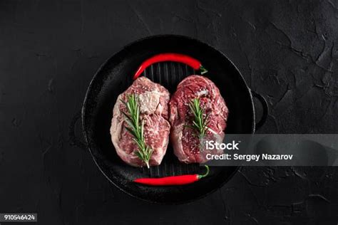 신선한 원료 고기입니다 쇠고기 안심 구이 양념 검은 배경 평면도 그릴 팬 및 프라이팬 보드에 두 개의 대리석된 쇠고기 스테이크 검은색에 대한 스톡 사진 및 기타 이미지