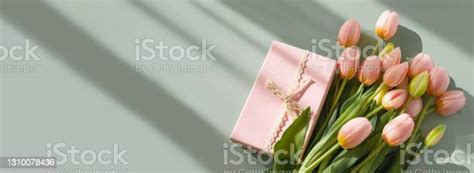 분홍색 튤립과 그림자가 있는 녹색 배경에 고립된 선물 상자의 꽃다발 봄 꽃 생일 여자 어머니의 날 결혼식 발렌타인 데이를위한 인사말 카드 플랫 레이 공간을 복사합니다 기치