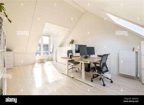 Bright And Airy Modern Office Space Featuring Sleek Furniture Dual Computer Setups And Large