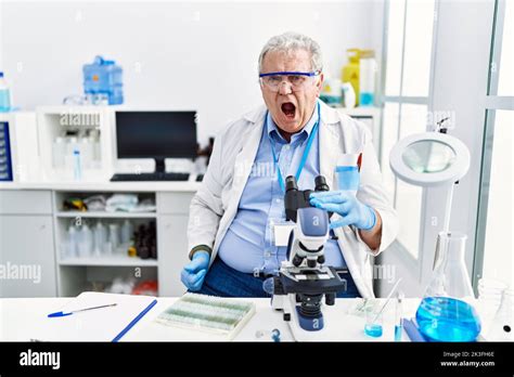 Senior Caucasian Man Working At Scientist Laboratory Angry And Mad Screaming Frustrated And