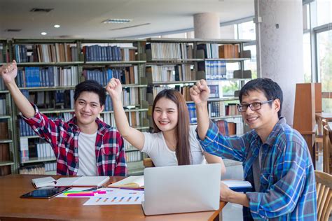 Asian University Students Read Books And Study Together In The Library